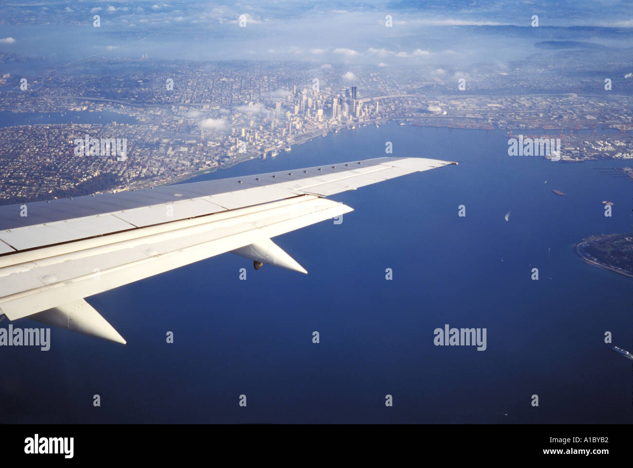 Downtown Seattle and Elliot Bay are seen over the wing of a 737 as it ...
