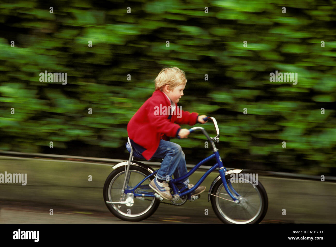 A six year old boy speeds determinedly on his first bicycle Stock Photo ...