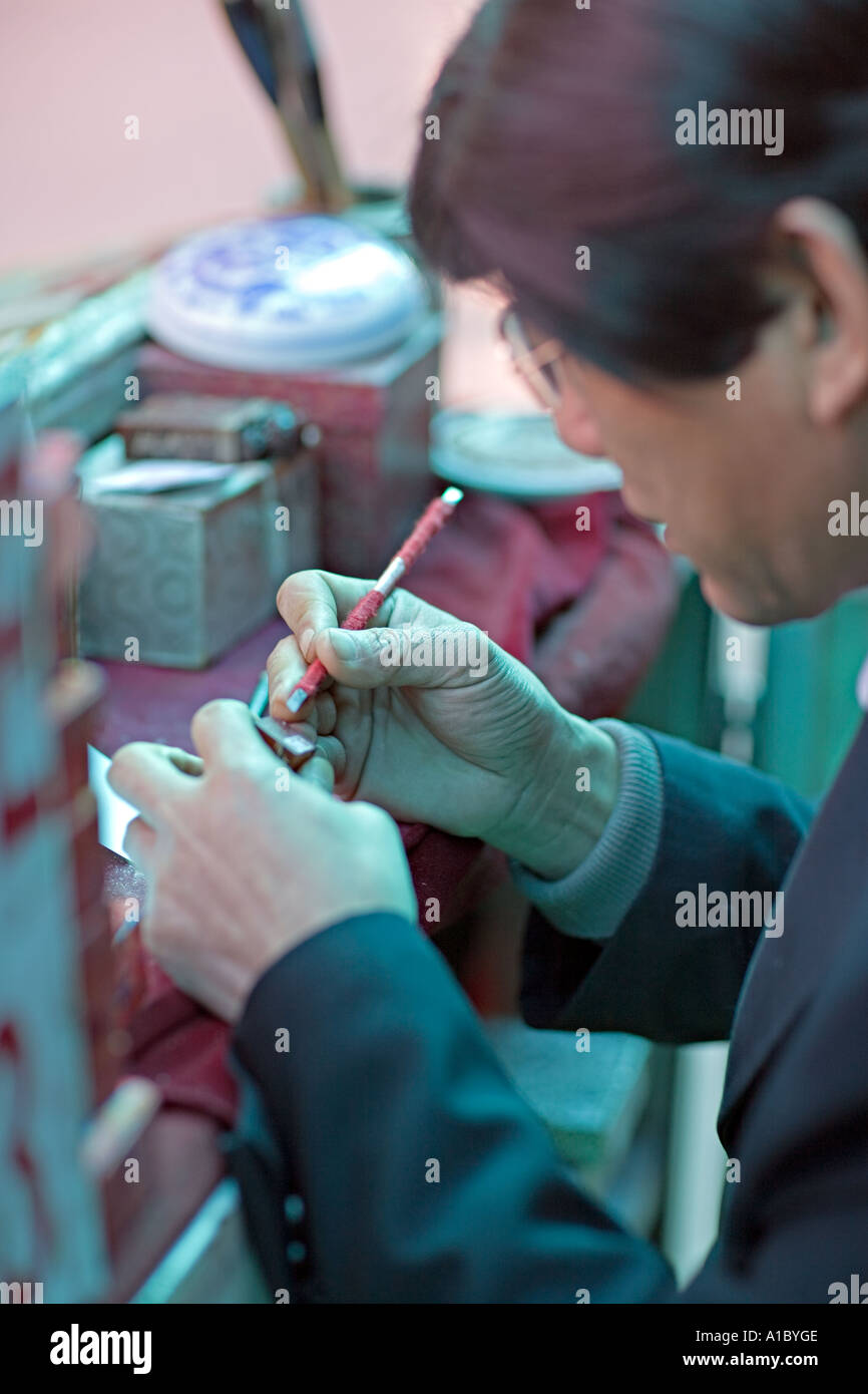 CHINA BEIJING Chinese artist carving chop for tourist customer Stock ...