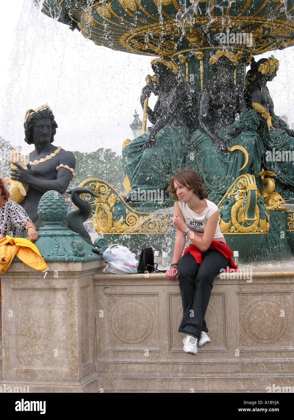 teenage girl sitting on fountain edge on Place de la Concorde Paris ...
