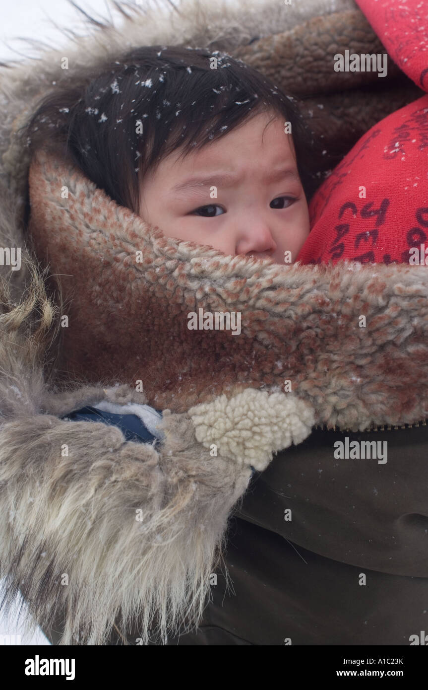 young Inupiat girl with her niece bundled up on her back Kaktovik ...
