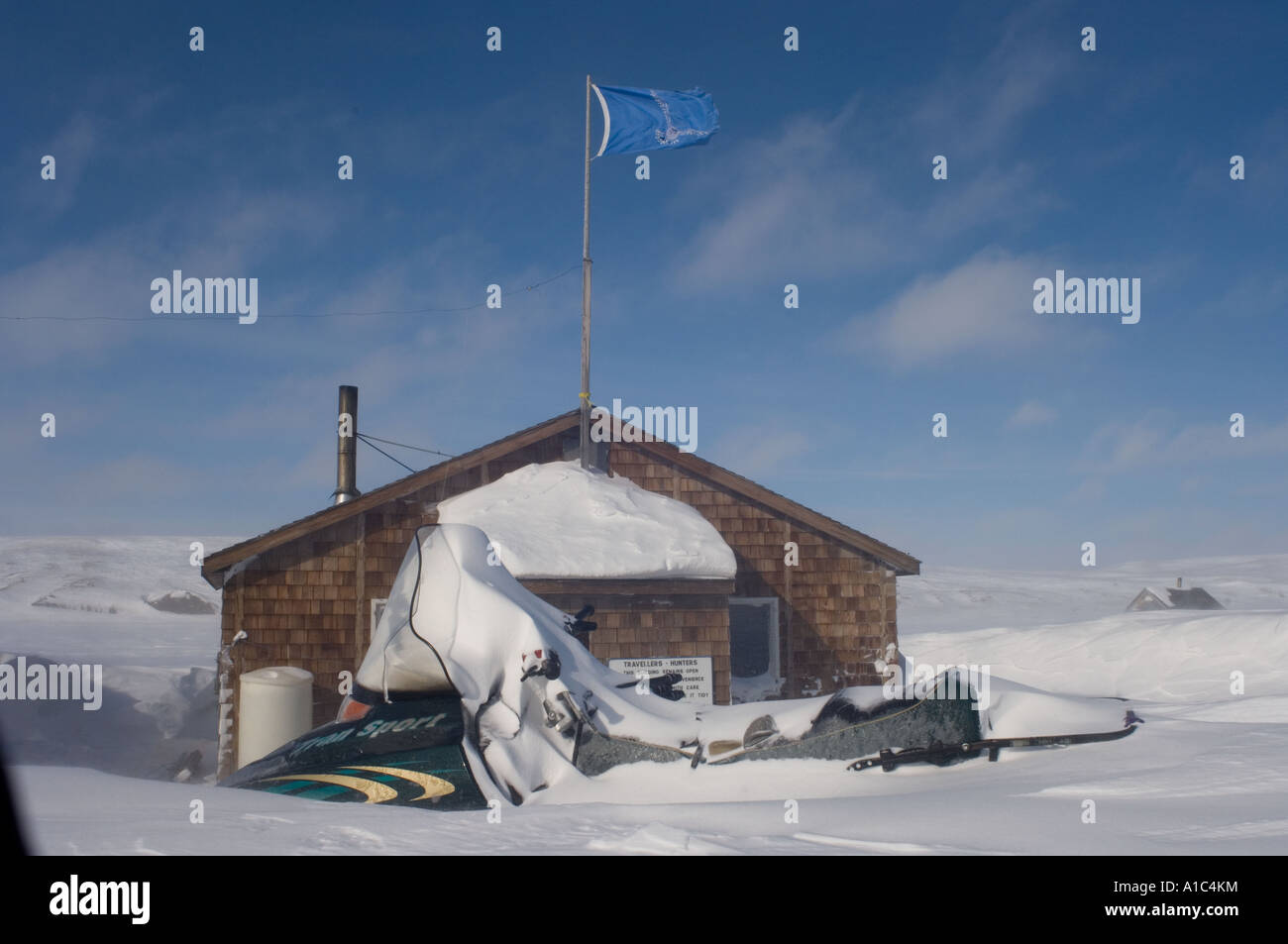 snow machine buried in snow in front of the hunter and trapper cabin on ...