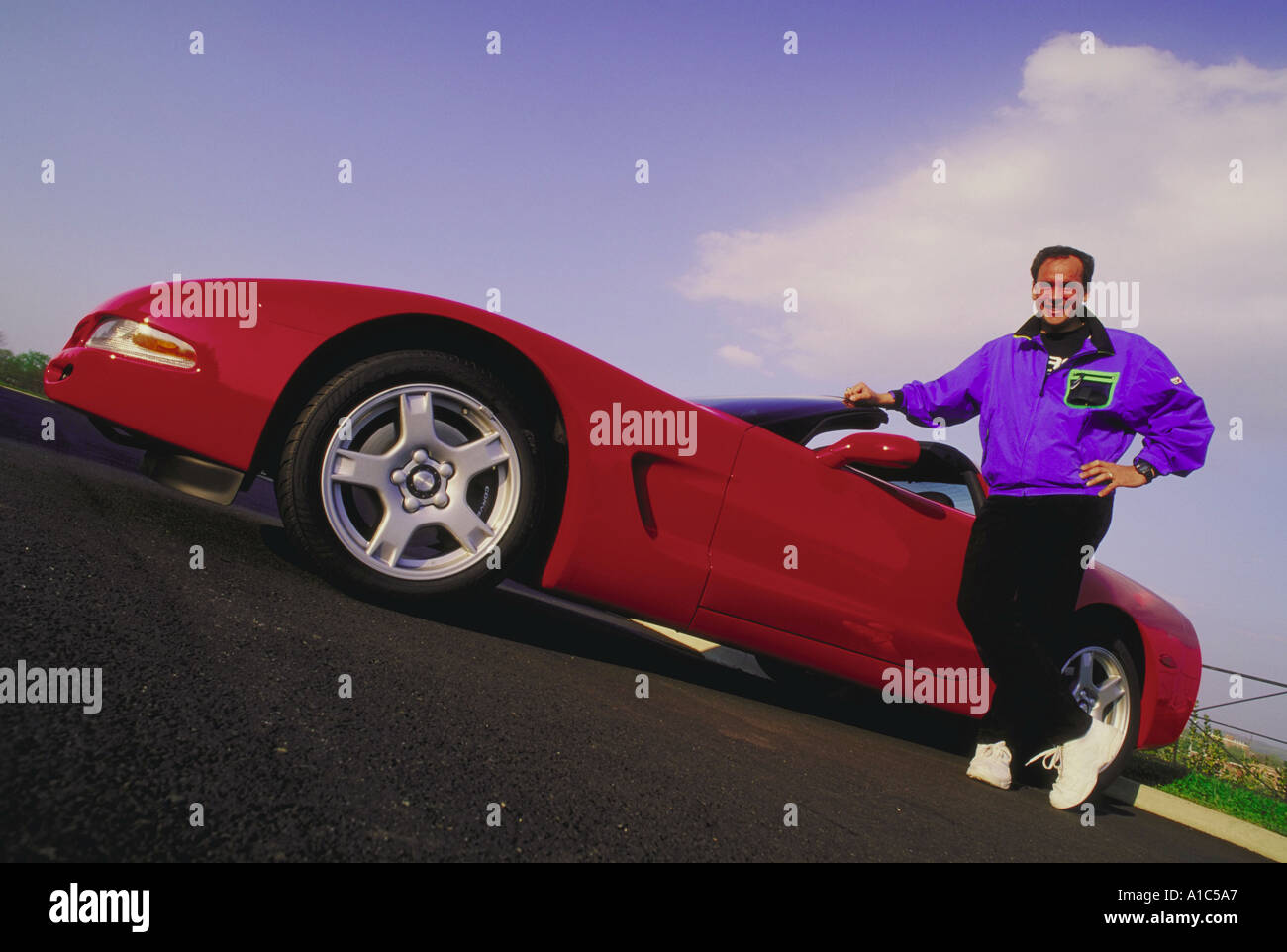 Man standing in front of convertible red Corvette Stock Photo - Alamy