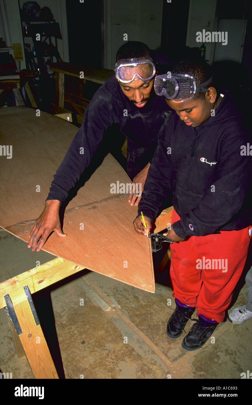 Black man teaching black boy how to use tools Taking social ...