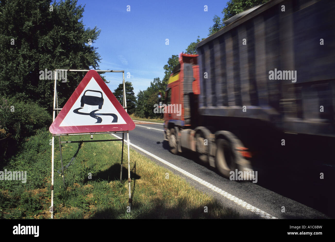 lorry passing warning sign of slippery road surface ahead uk Stock ...