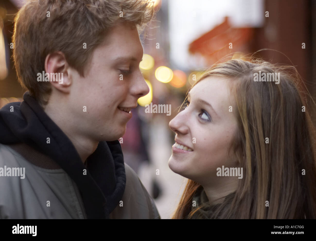 a teenage couple aged 16 on day trip to London at Chinatown at dusk ...