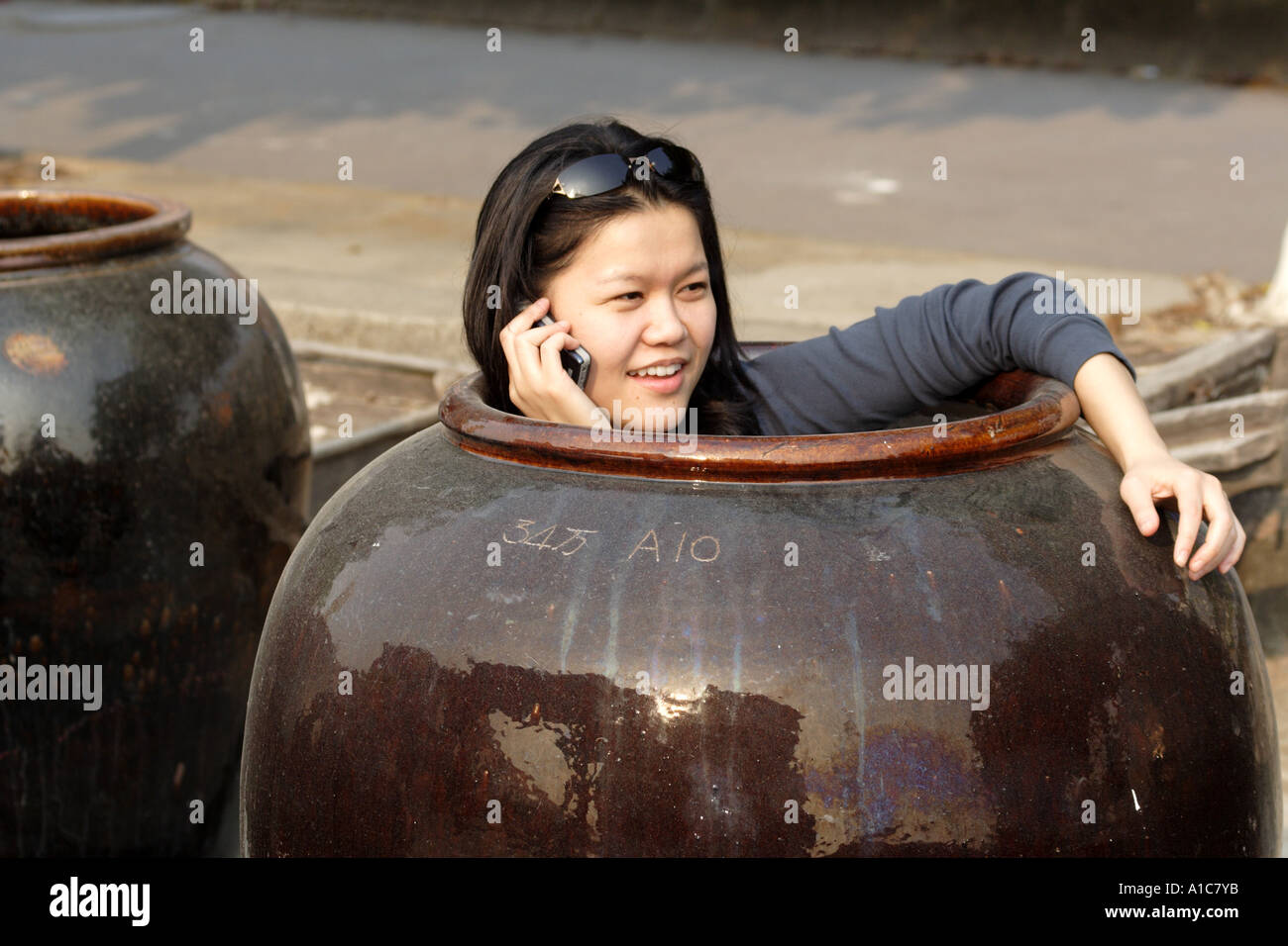 Shan takes a call from inside an antique pot at the Zhongshan China ...