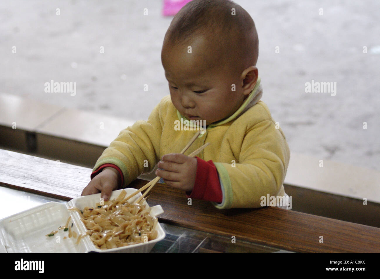 Baby learning to use chopsticks Zhongshan China Stock Photo - Alamy