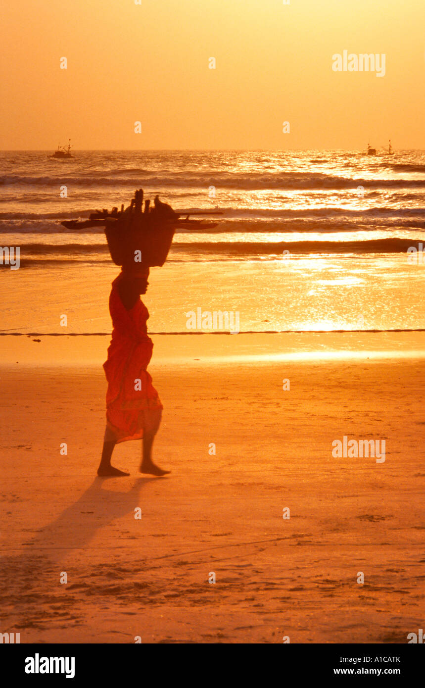 Indigenous woman on Benaulim beach. Sunset in the background Salcete ...