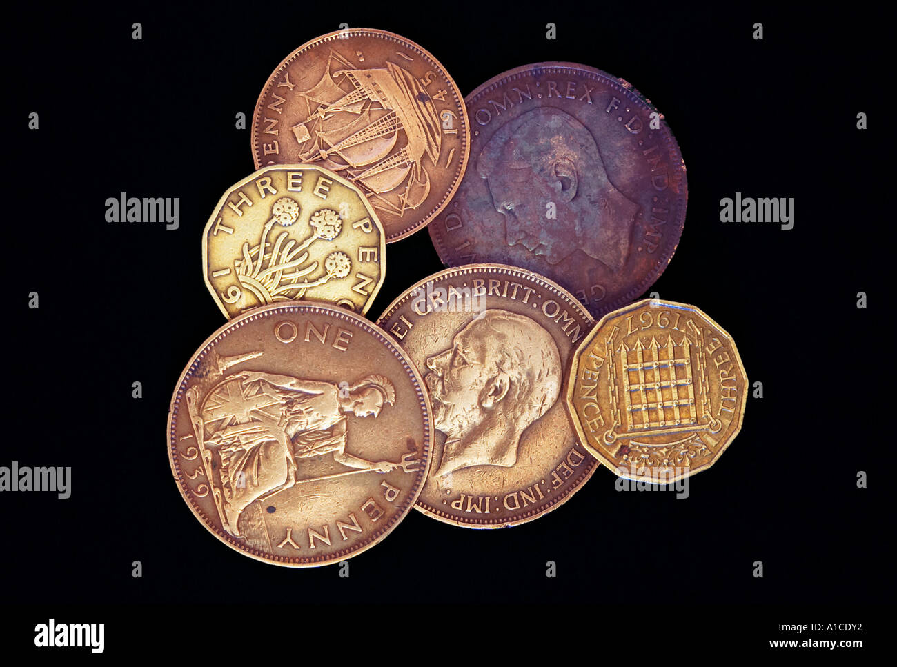 Pre decimalisation 20th Century UK coinage against a black background ...