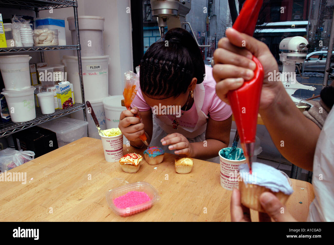 Girls from the Lower East Side Girls Club bake and frost cupcakes at ...