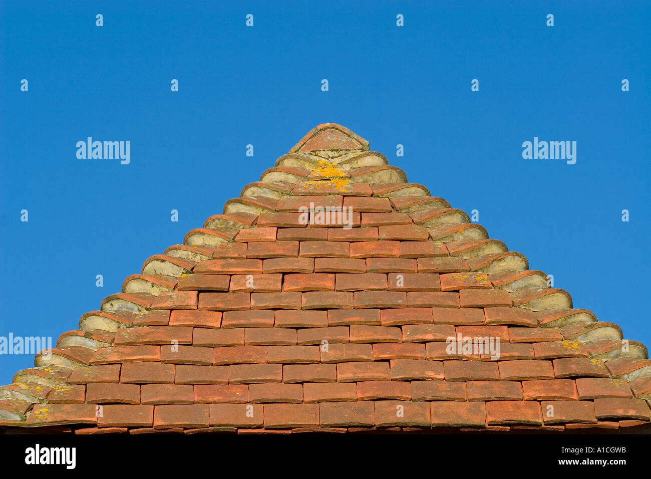 The apex of a traditionally tiled British roof Stock Photo - Alamy