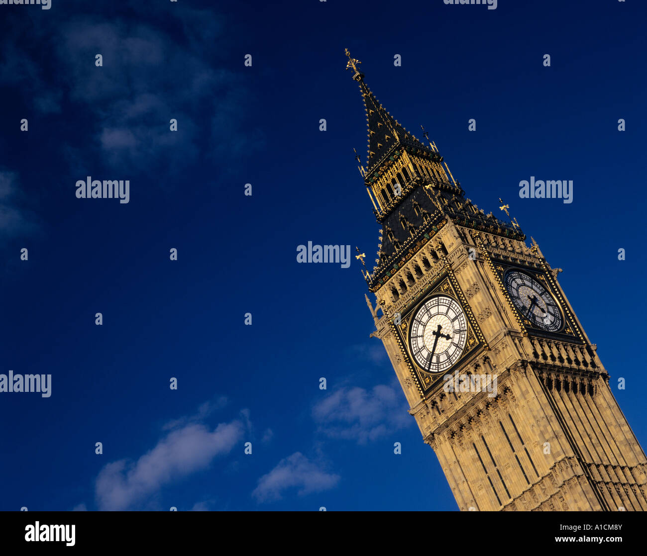The top of Big Ben in London England. There is a blue sky in behind ...