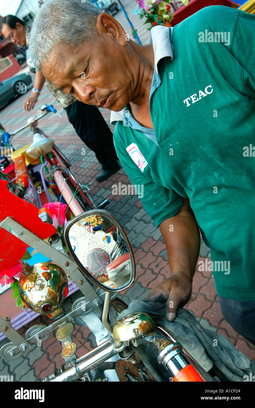 Driver polishes old fashioned rickshaw bell Melaka Malaysia Stock Photo ...