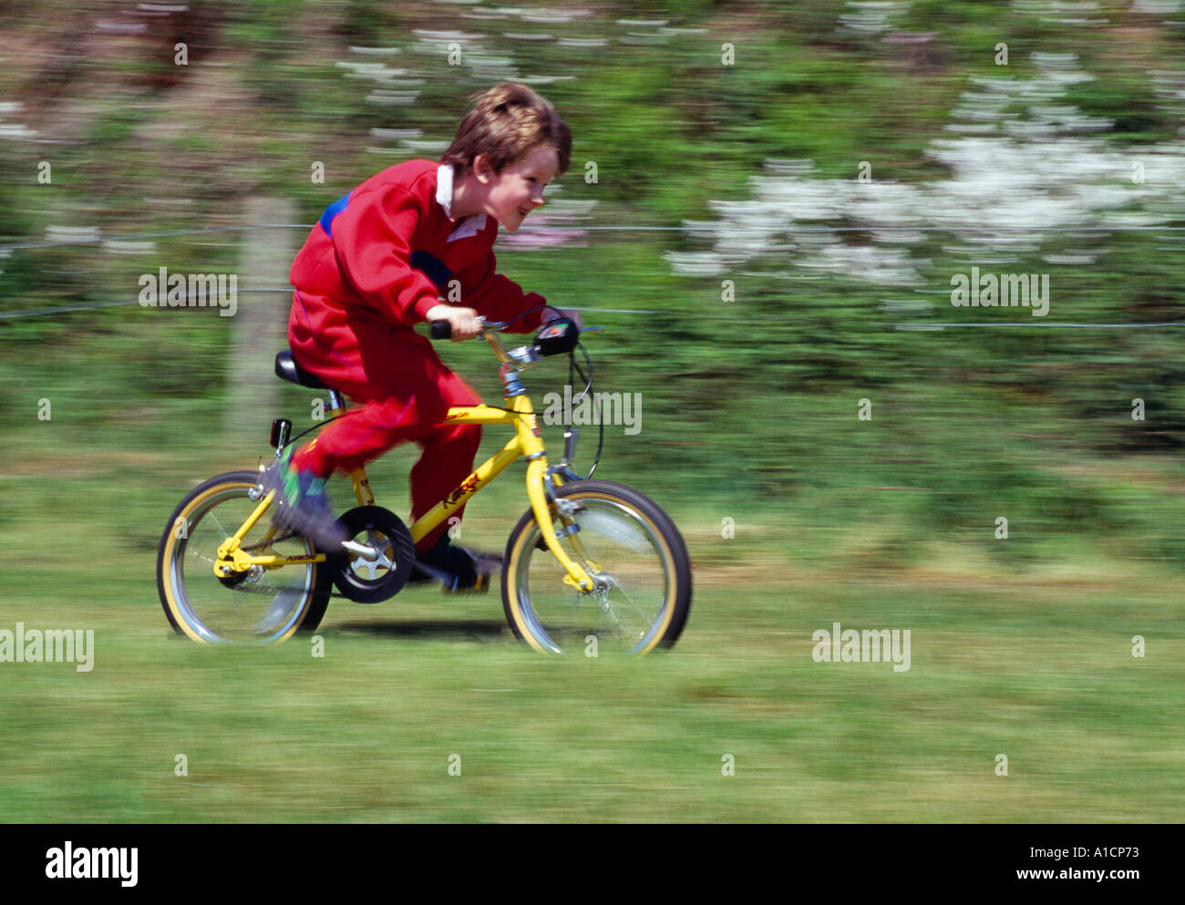 LITTLE BOY AGED SIX ON YELLOW BICYCLE MOVING FAST IN COUNTRY SIDE UK ...