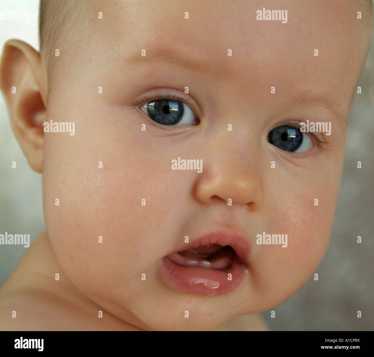 A close up a babys face. The baby looks scared or startled Stock Photo ...
