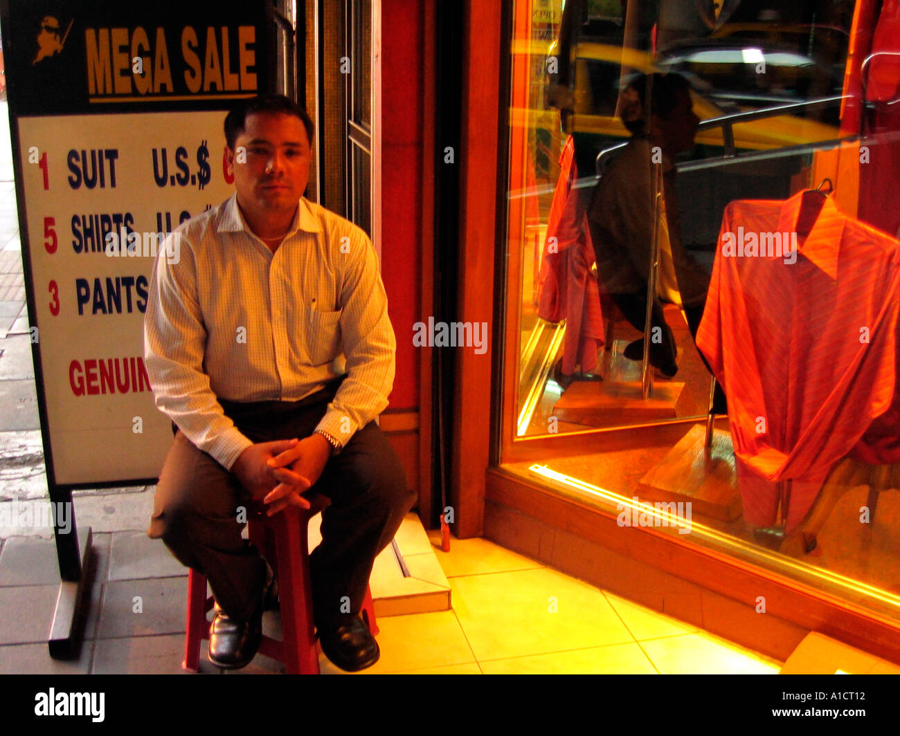 Salesman sits on pavement outside tailors shop Bangkok Stock Photo - Alamy