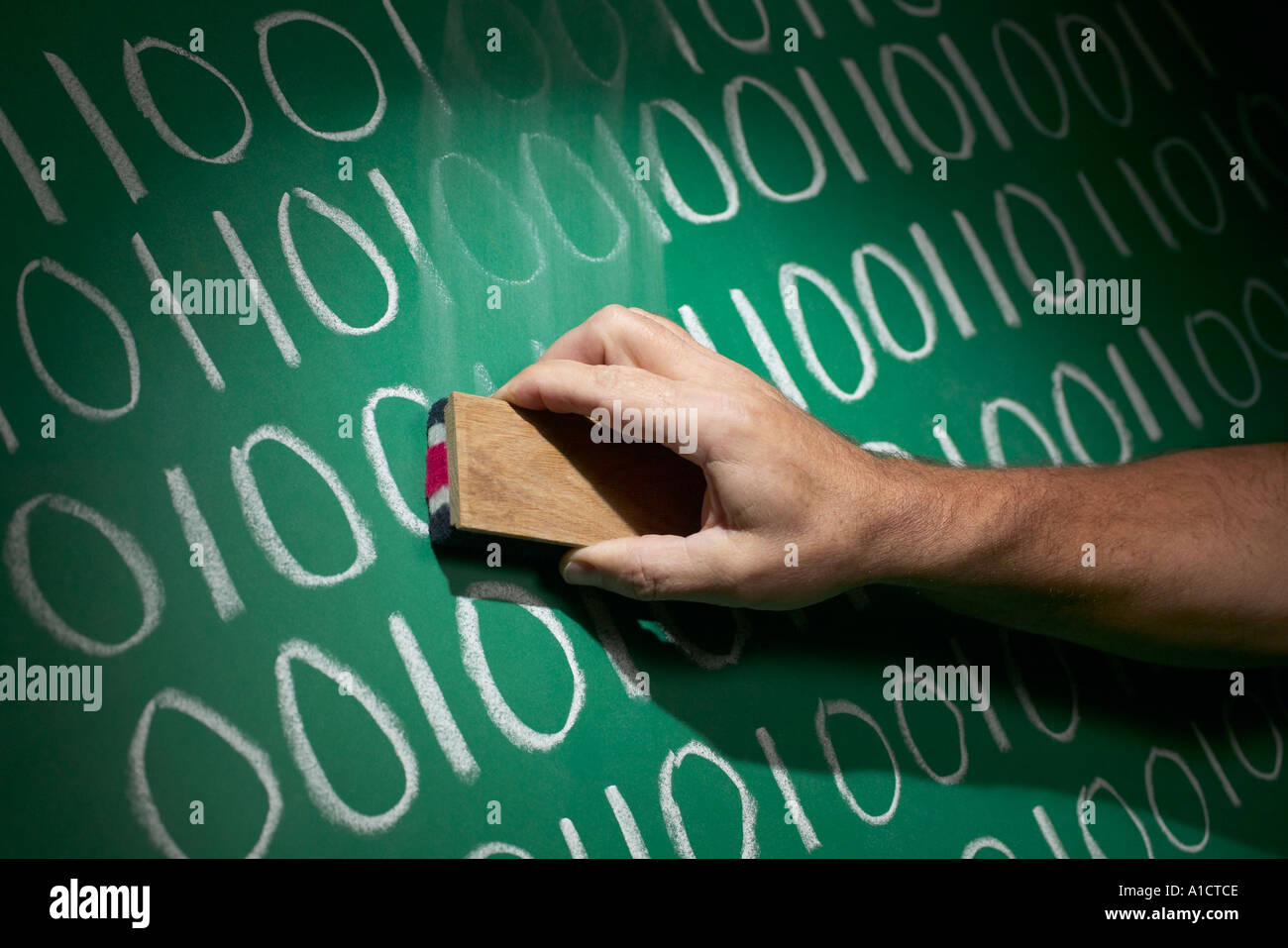 Hand erasing binary numbers on blackboard Stock Photo - Alamy