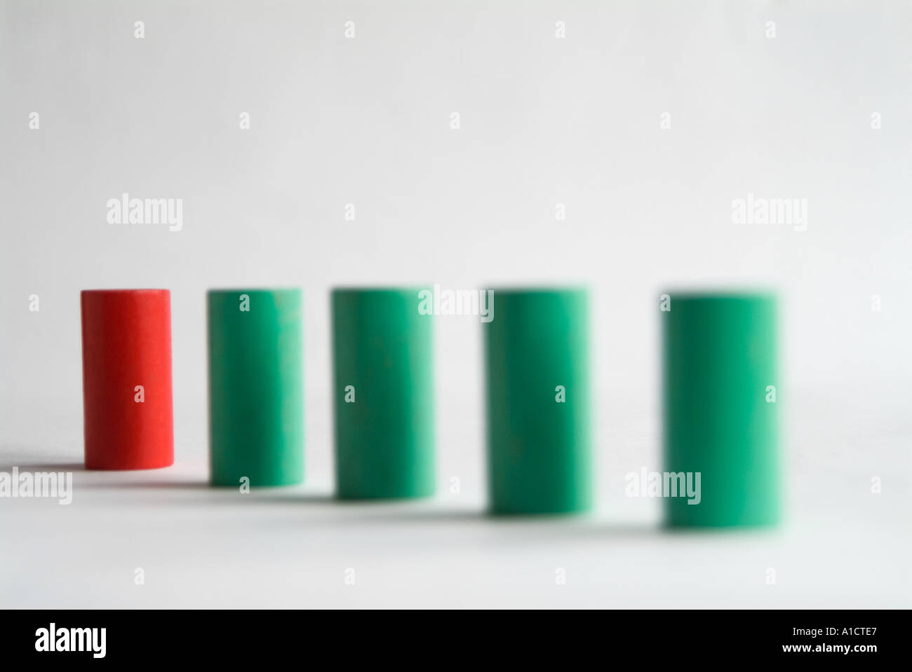 four green and one red cylindrical toy wooden blocks on white ...