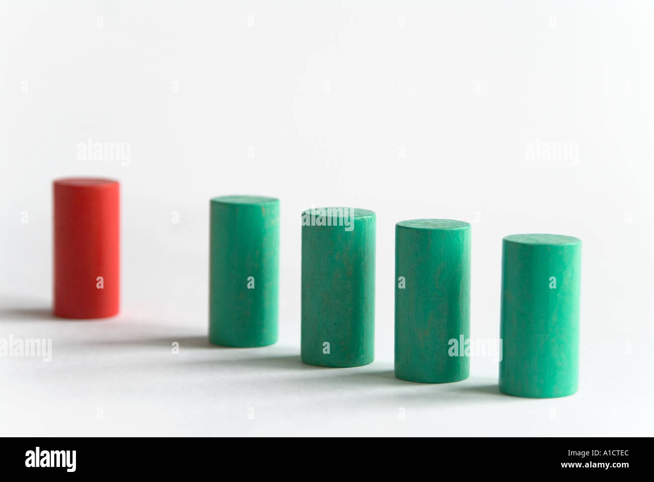 four green and one red cyclindrical toy wooden blocks on white ...