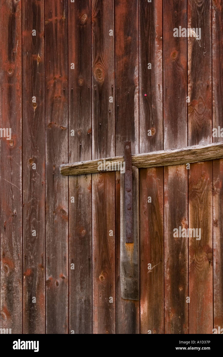 Old rustic barn door heavily weathered with old timbered bar and rusted ...