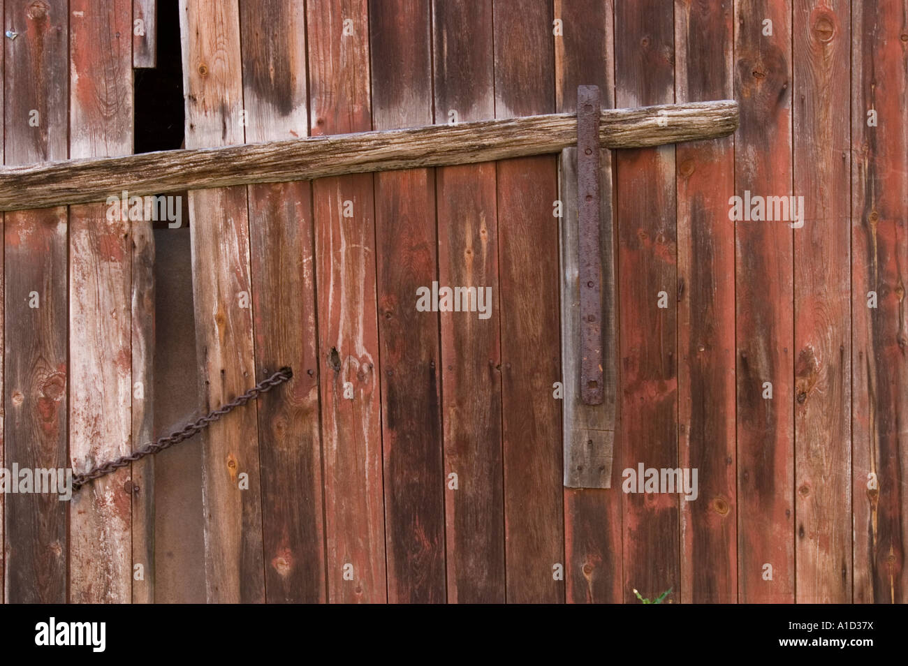 Old rustic barn door heavily weathered with old timbered bar and rusted ...