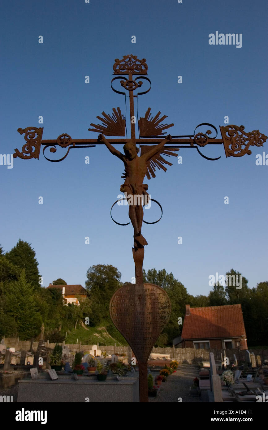 Corroded iron crucifix over grave in churchyard cemetry with figure of ...