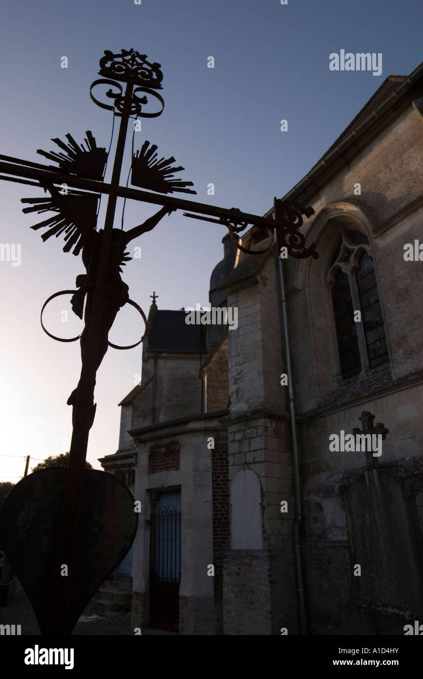 Corroded iron crucifix over grave in churchyard cemetry with figure of ...