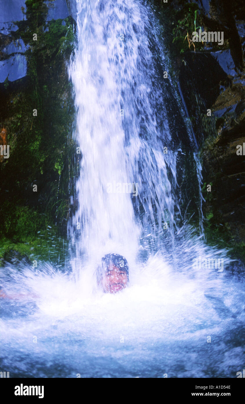 Cooling off under the waterfall while trekking Stock Photo - Alamy