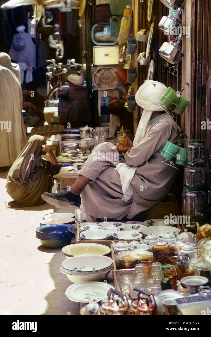 shopkeeper sitting outside shop selling crokery waiting for customer ...