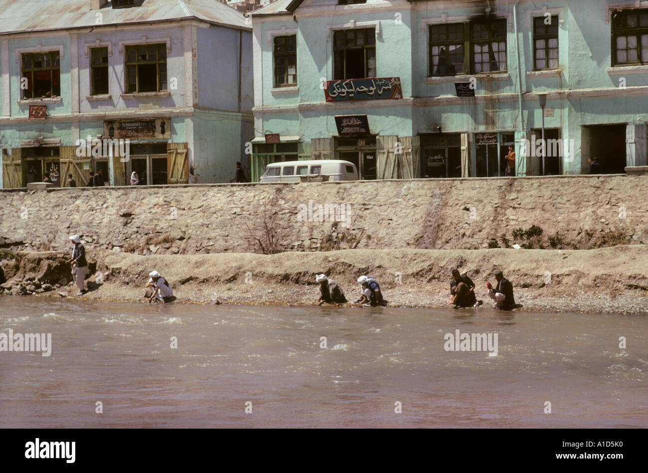 Kabul City River in full flow with people doing their daily ablutions ...