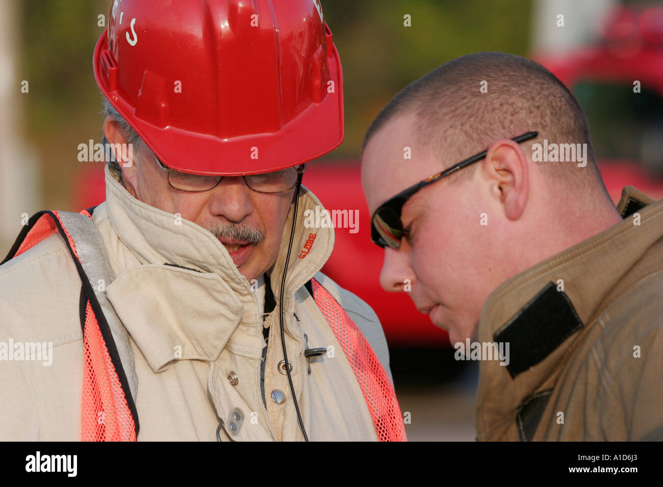 Fire fighters talking and recording information at an emergency scene ...