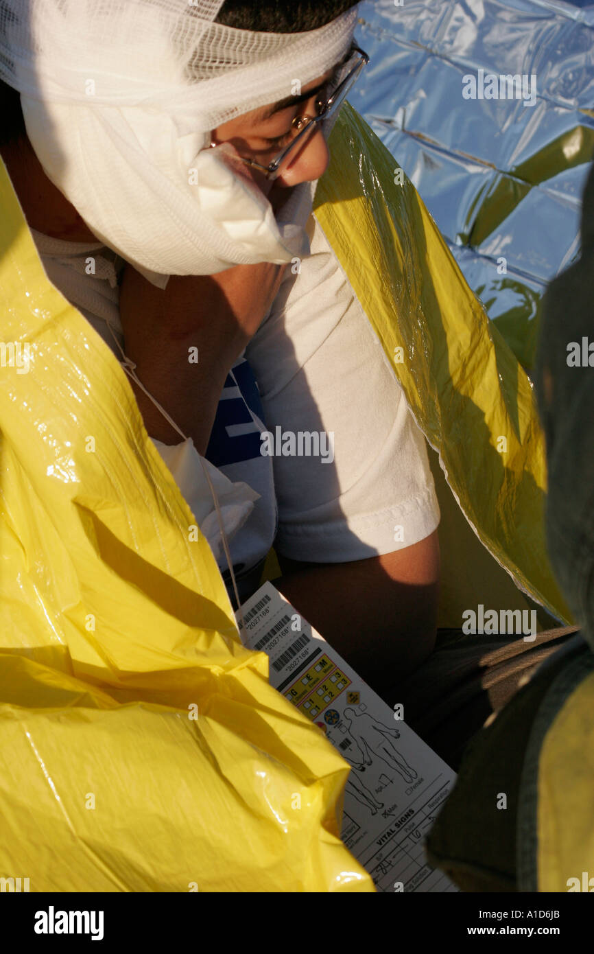 A young hurt boy is sitting with bandages waiting to be transported to ...