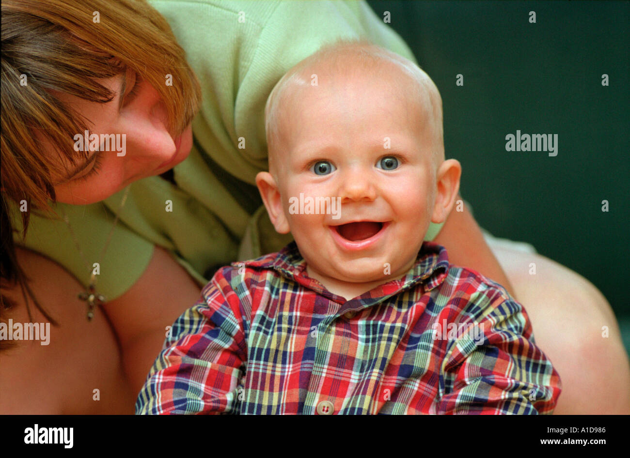 A joyful Mother and Baby Mother aged 31 baby aged 1 looking into camera ...
