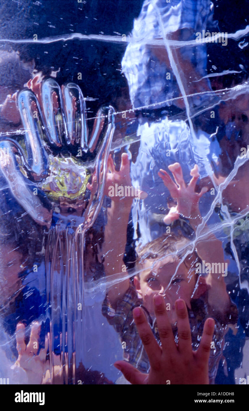 Abstract of a melting handprint on a block of ice with child spectators ...
