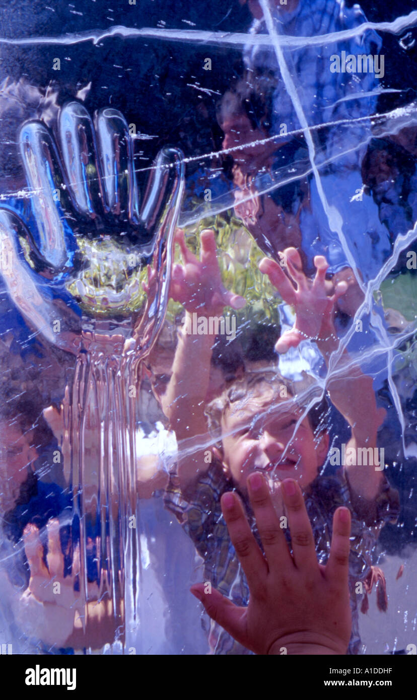 Abstract of a melting handprint on a block of ice with child spectators ...