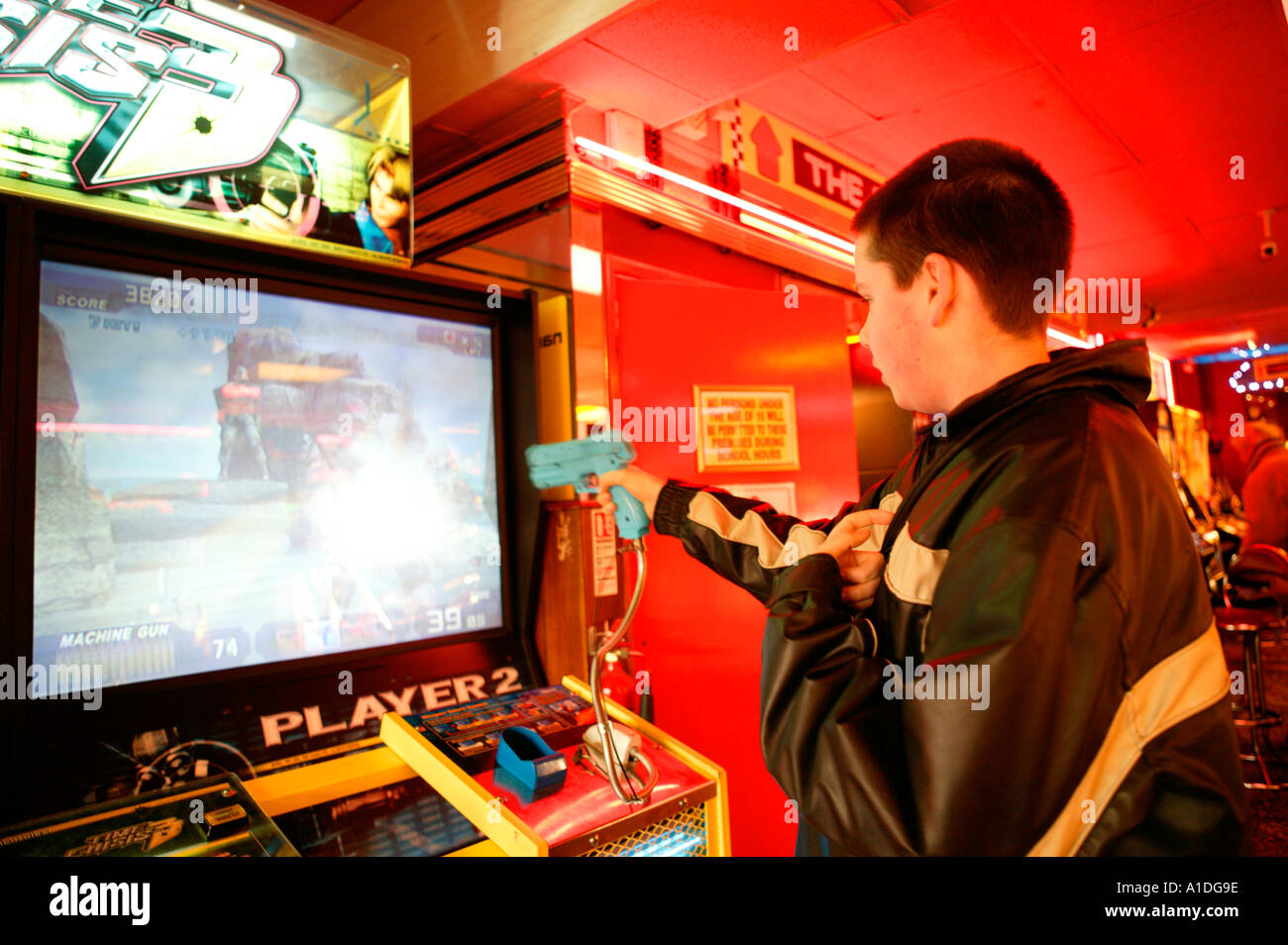 Boy on Video Game in Arcade Stock Photo - Alamy