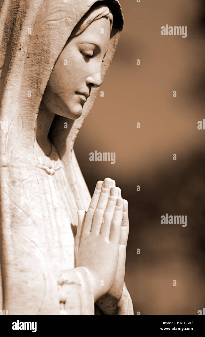 Cemetery statue of Mary praying Stock Photo - Alamy