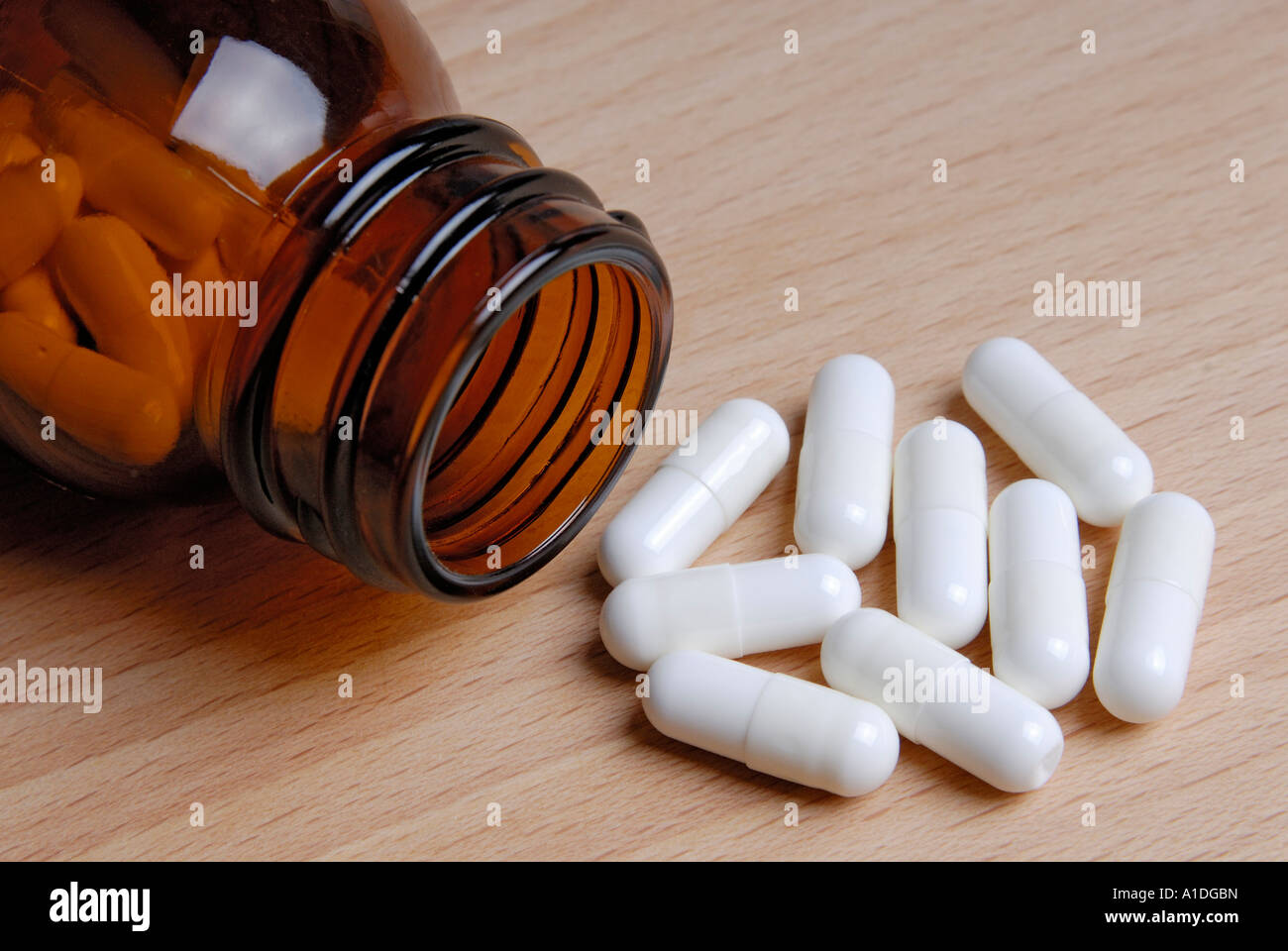 Tablets lying in front of a bottle Stock Photo - Alamy