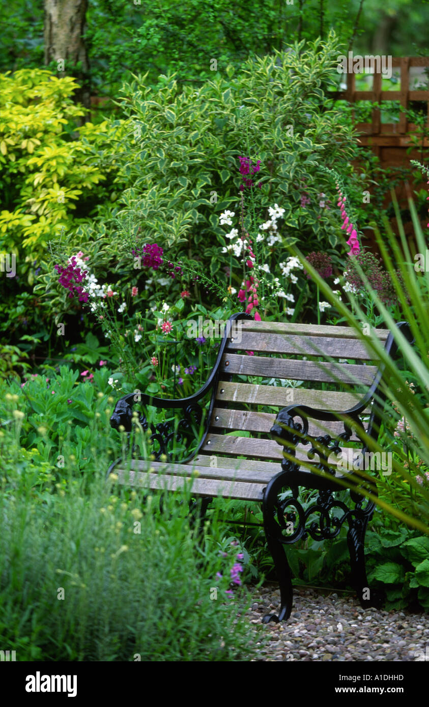 bench in well planted garden with lots of foliage Stock Photo - Alamy