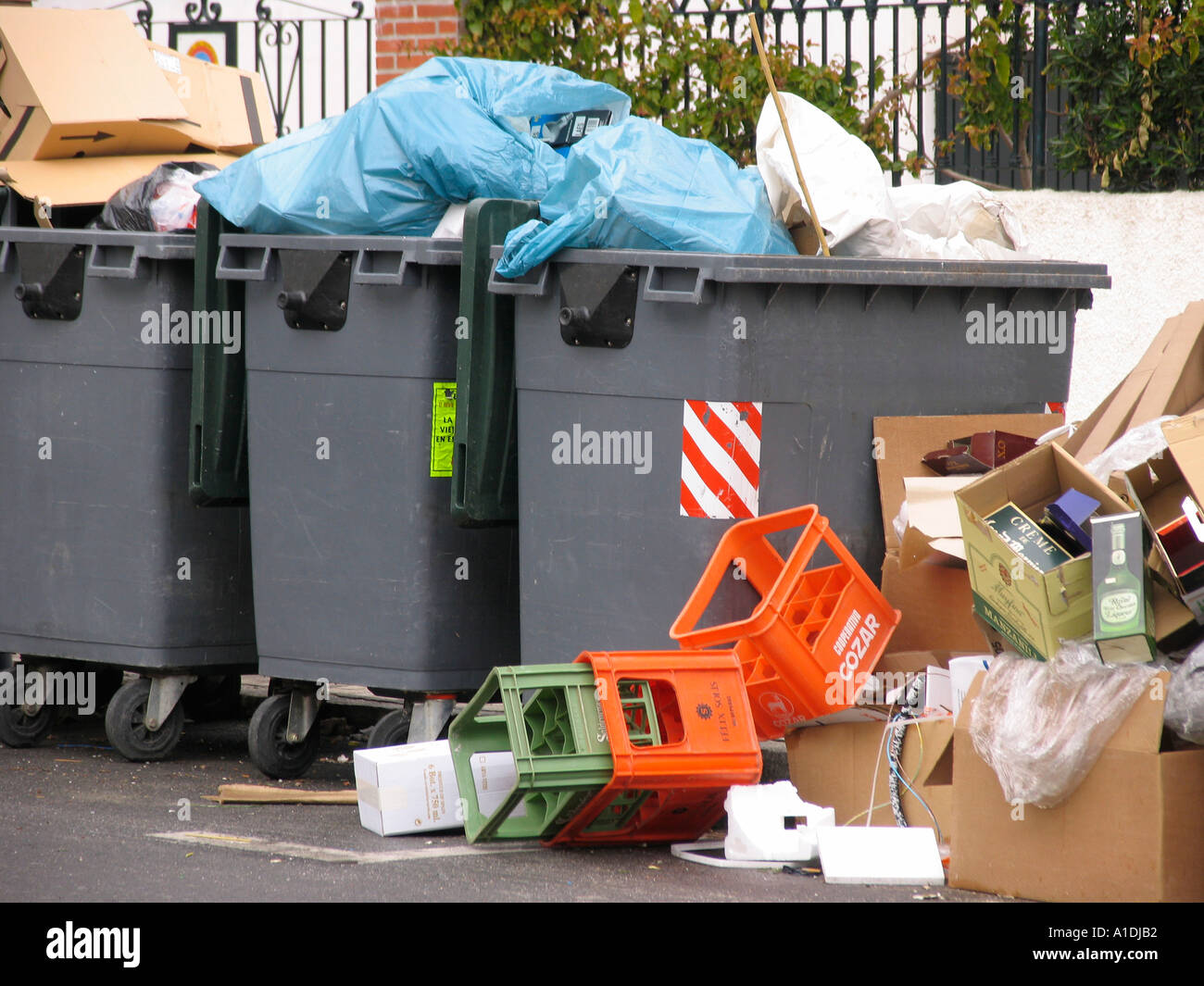 Overflowing rubbish containers in urban setting Stock Photo - Alamy