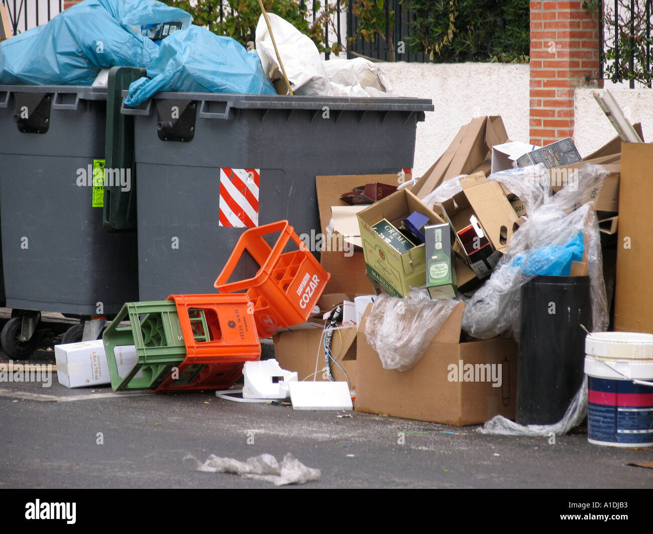 Overflowing rubbish containers in urban setting Stock Photo - Alamy