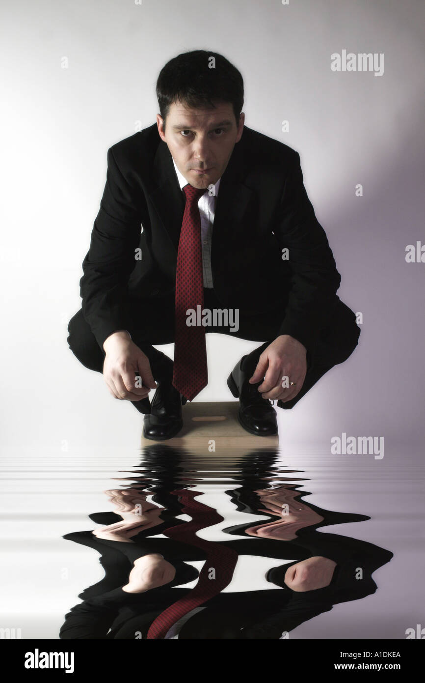 Business man crouched on stool hi-res stock photography and images - Alamy