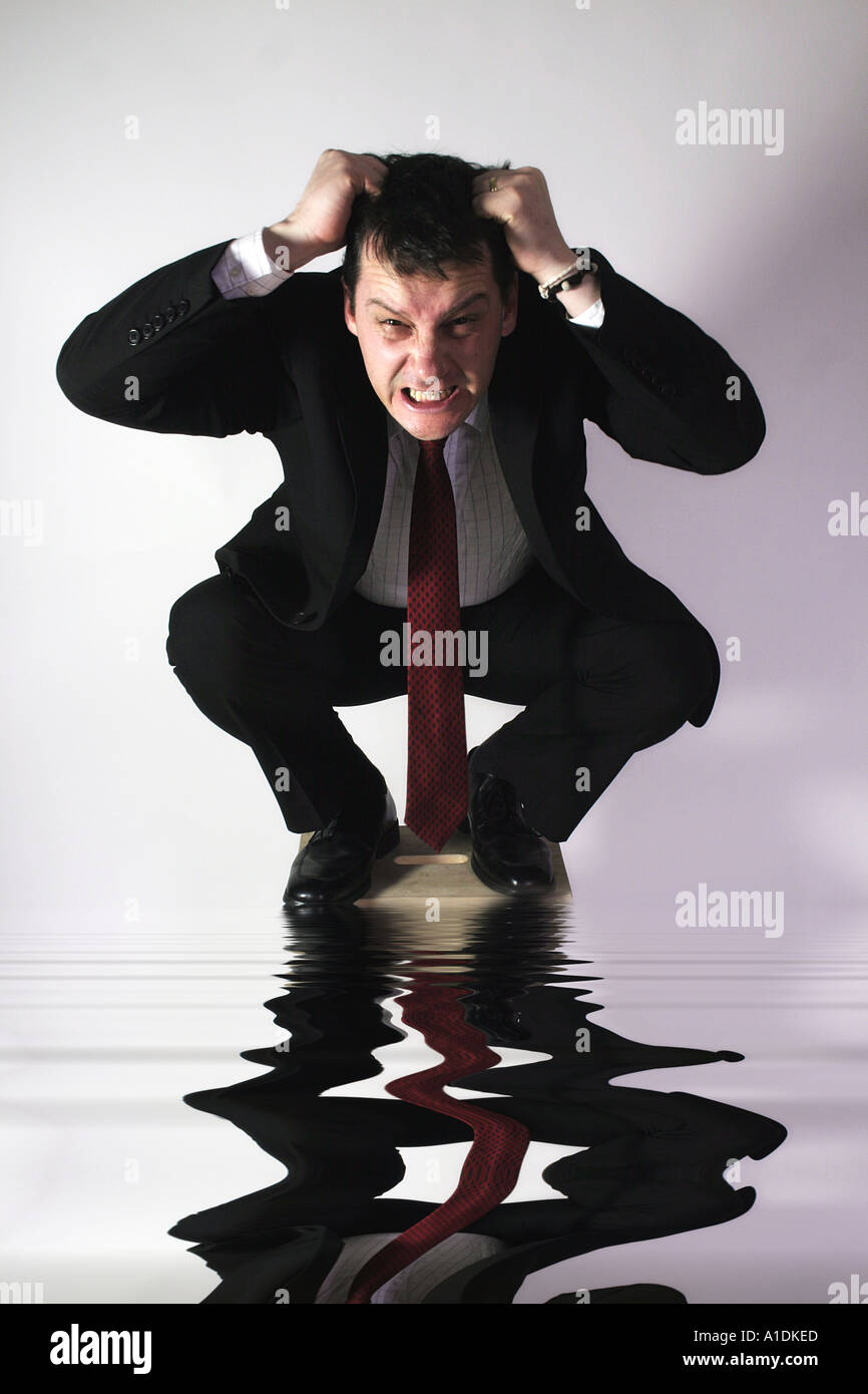 Business man crouched on stool hi-res stock photography and images - Alamy