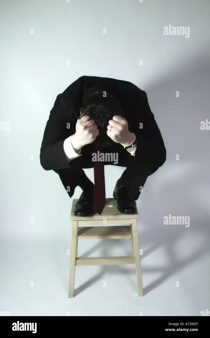 Business man crouched on stool hi-res stock photography and images - Alamy