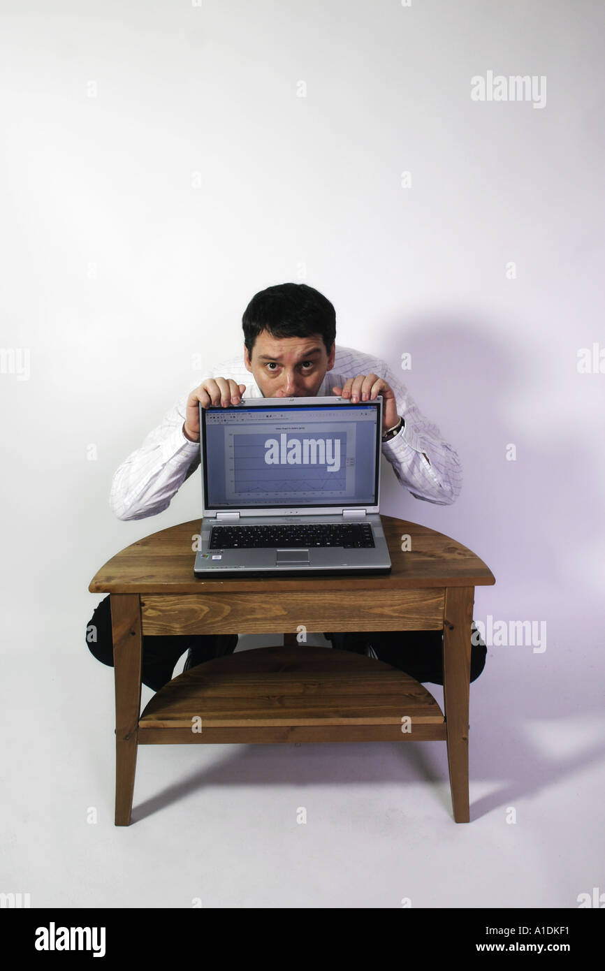 Man hiding behind laptop hi-res stock photography and images - Alamy
