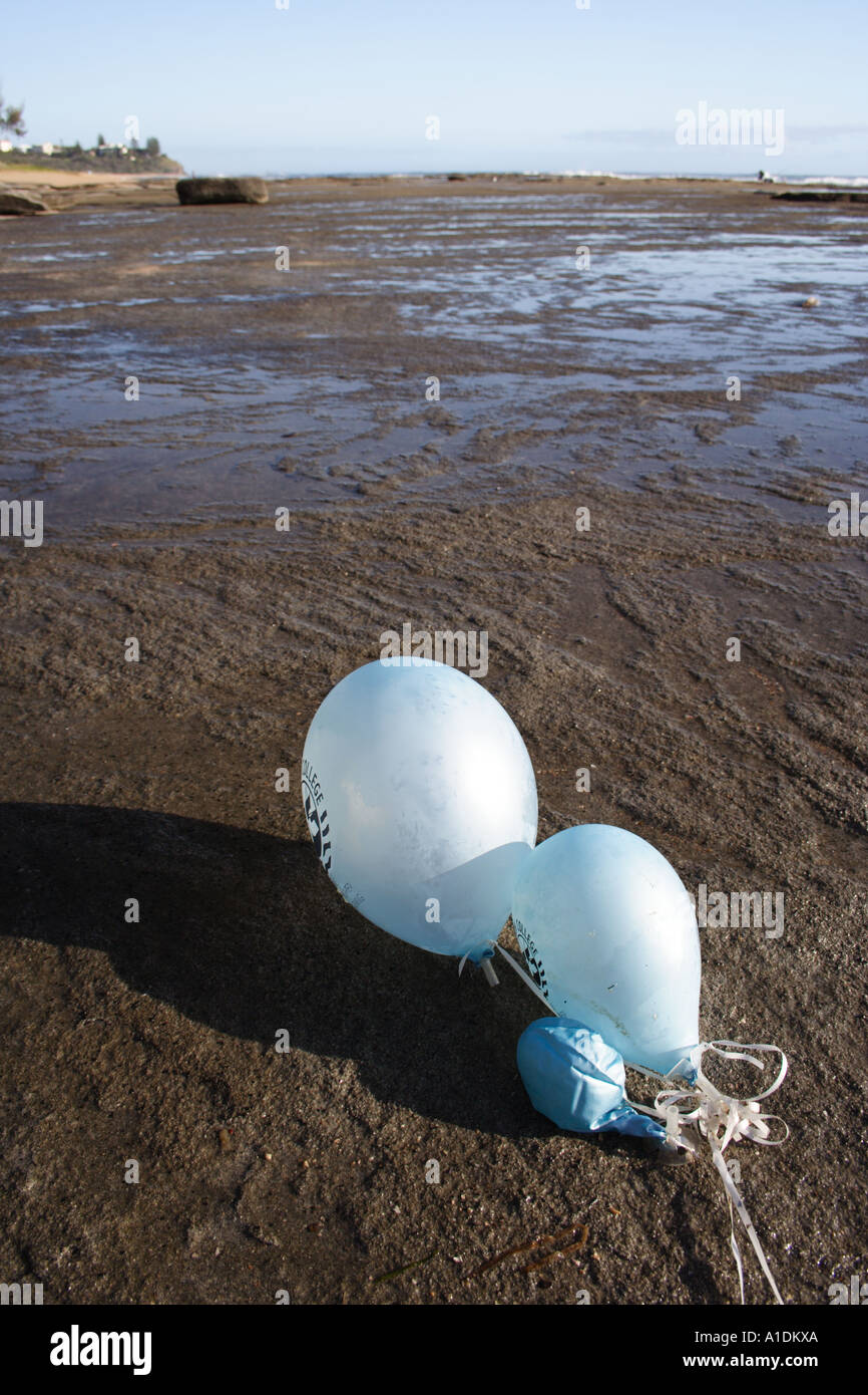 PARTIALLY DEFLATED BALLOONS ON ROCKS AT A BEACH Stock Photo - Alamy