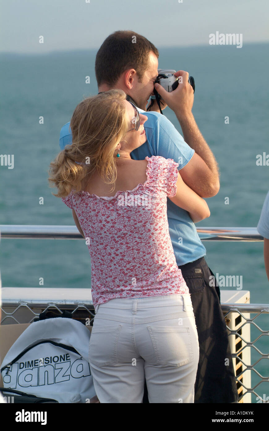 A young couple hug on a sunset cruise photo by Bruce Miller Stock Photo ...