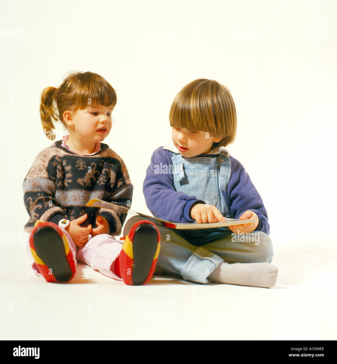 two kids looking at children`s book. Photo by Willy Matheisl Stock ...