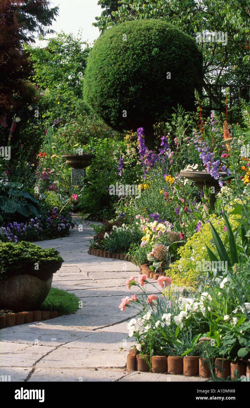 curved stone path through well planted garden Stock Photo - Alamy